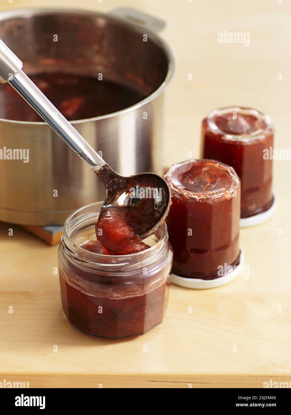 Filling the jam jars,turn over and leave to cool Stock Photo - Alamy
