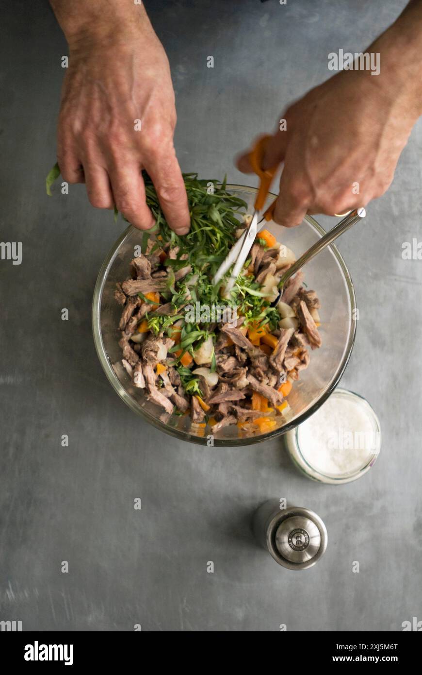 Adding the fresh herbs to the meat and the vegetables Stock Photo - Alamy