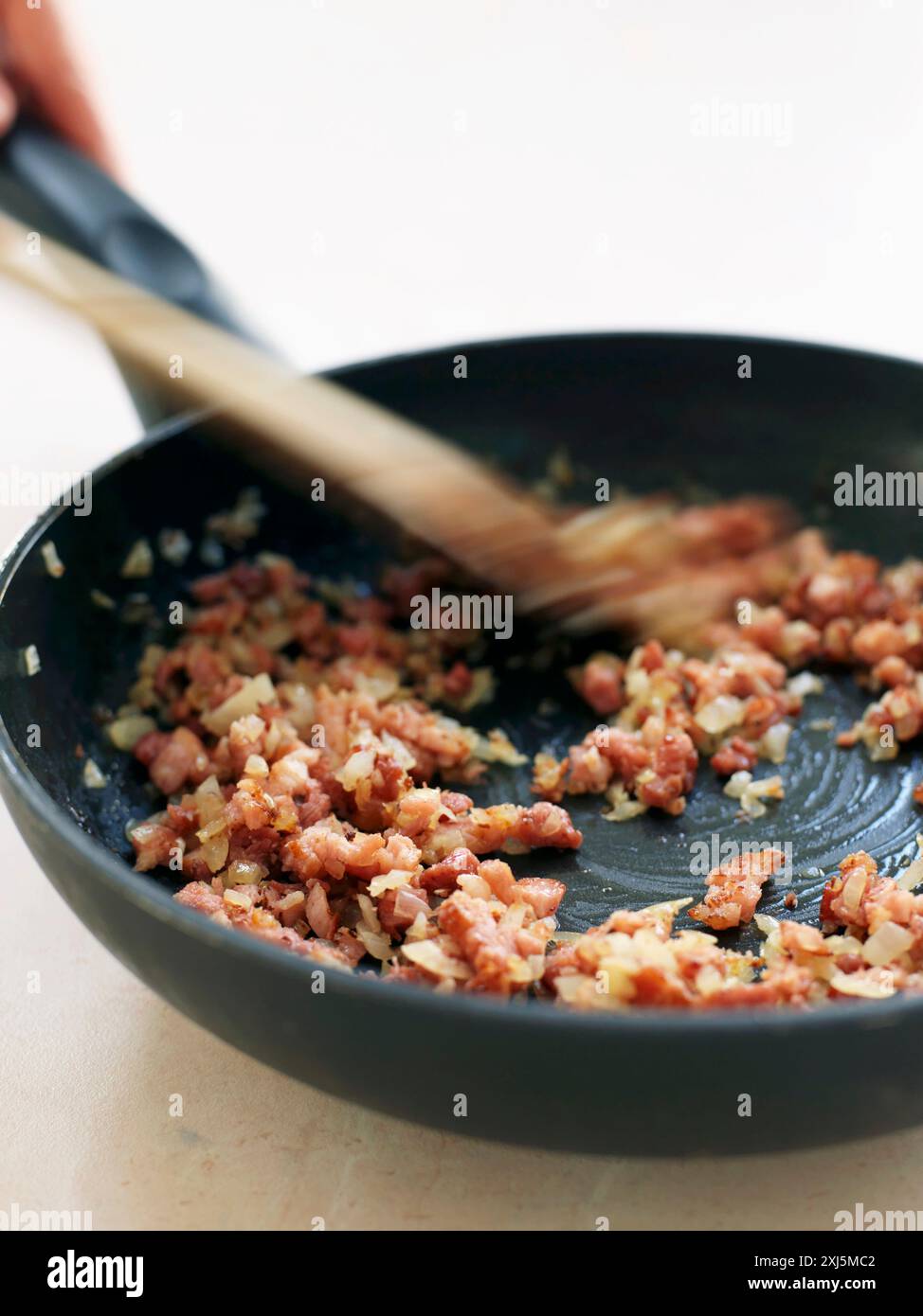 Cooking the diced bacon in a frying pan Stock Photo - Alamy