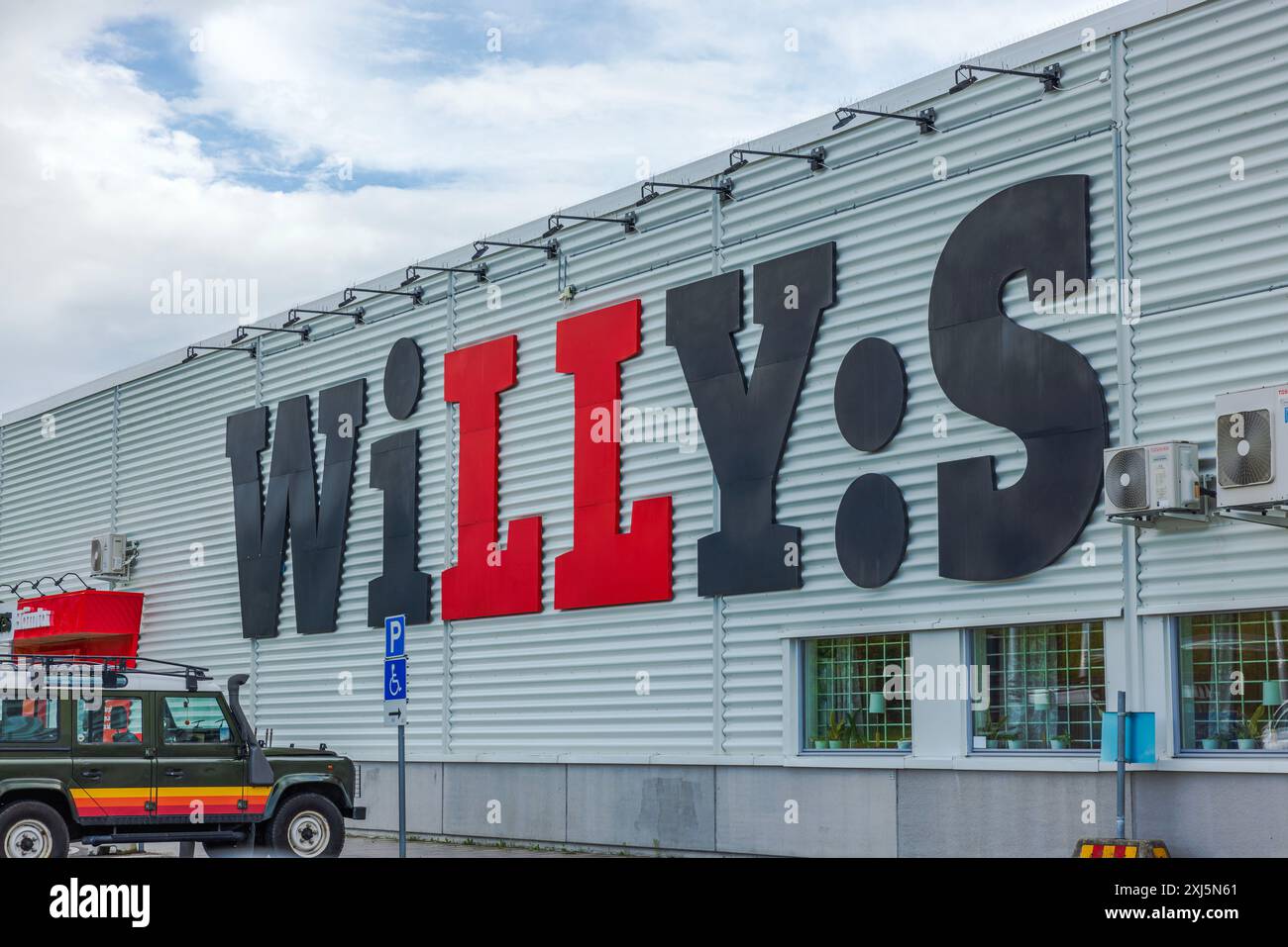 Willy:s supermarket building exterior with large sign and parked car in ...
