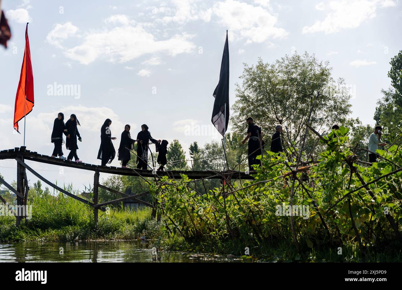 Kashmiri Shia Muslims walk on a wooden bridge to participate in a ...