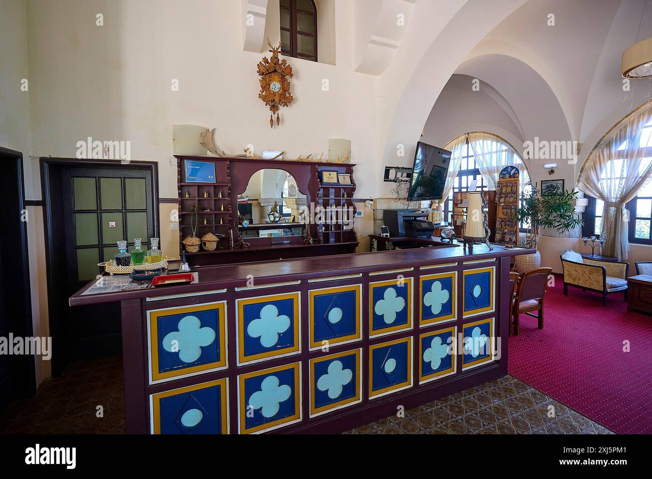 Elegant hotel reception with decorative counter, red carpets and arched ...