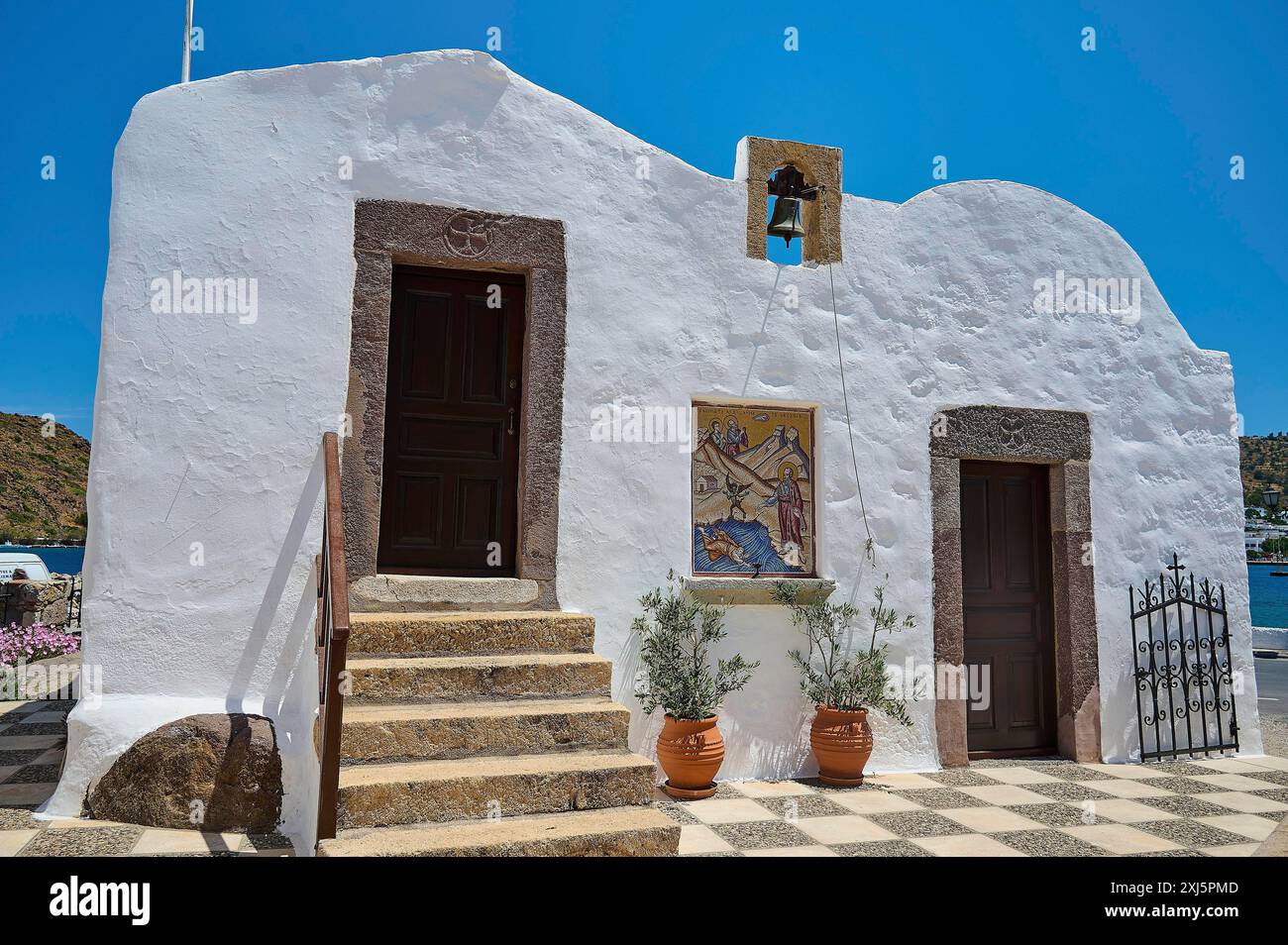 White building in traditional Greek style with staircase, two doors and ...