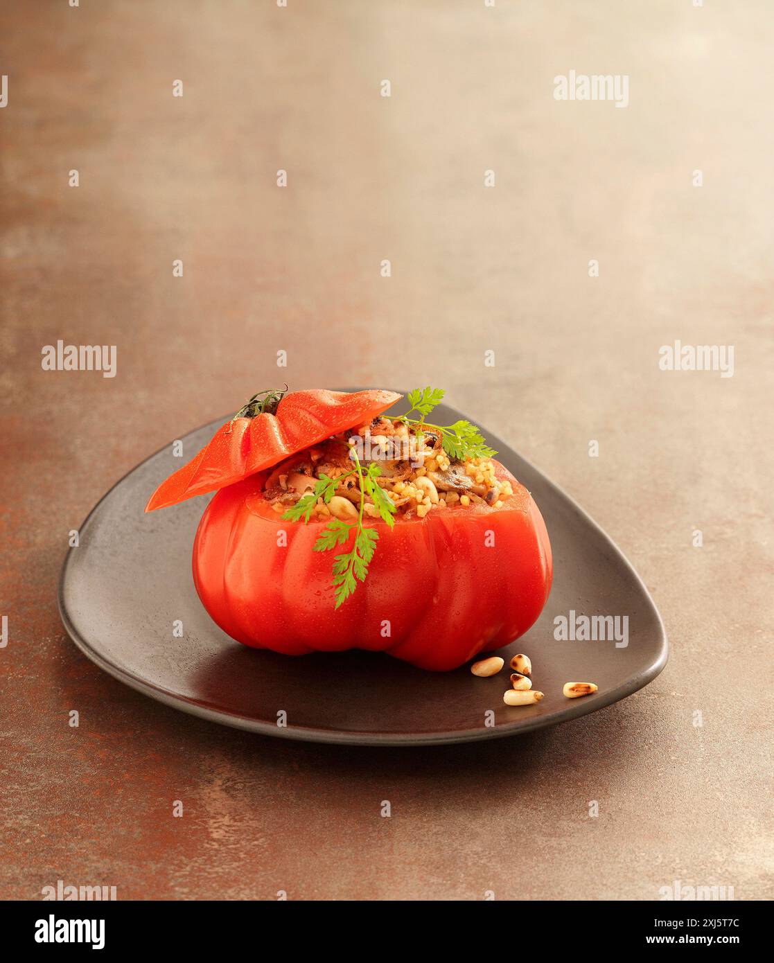Coeur de boeuf tomato stuffed with bulghour and pine nuts Stock Photo ...