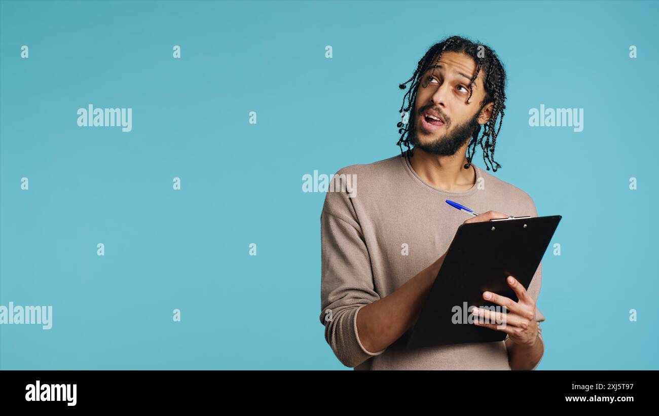 Middle Eastern photographer holding clipboard in hand, completing shoot ...