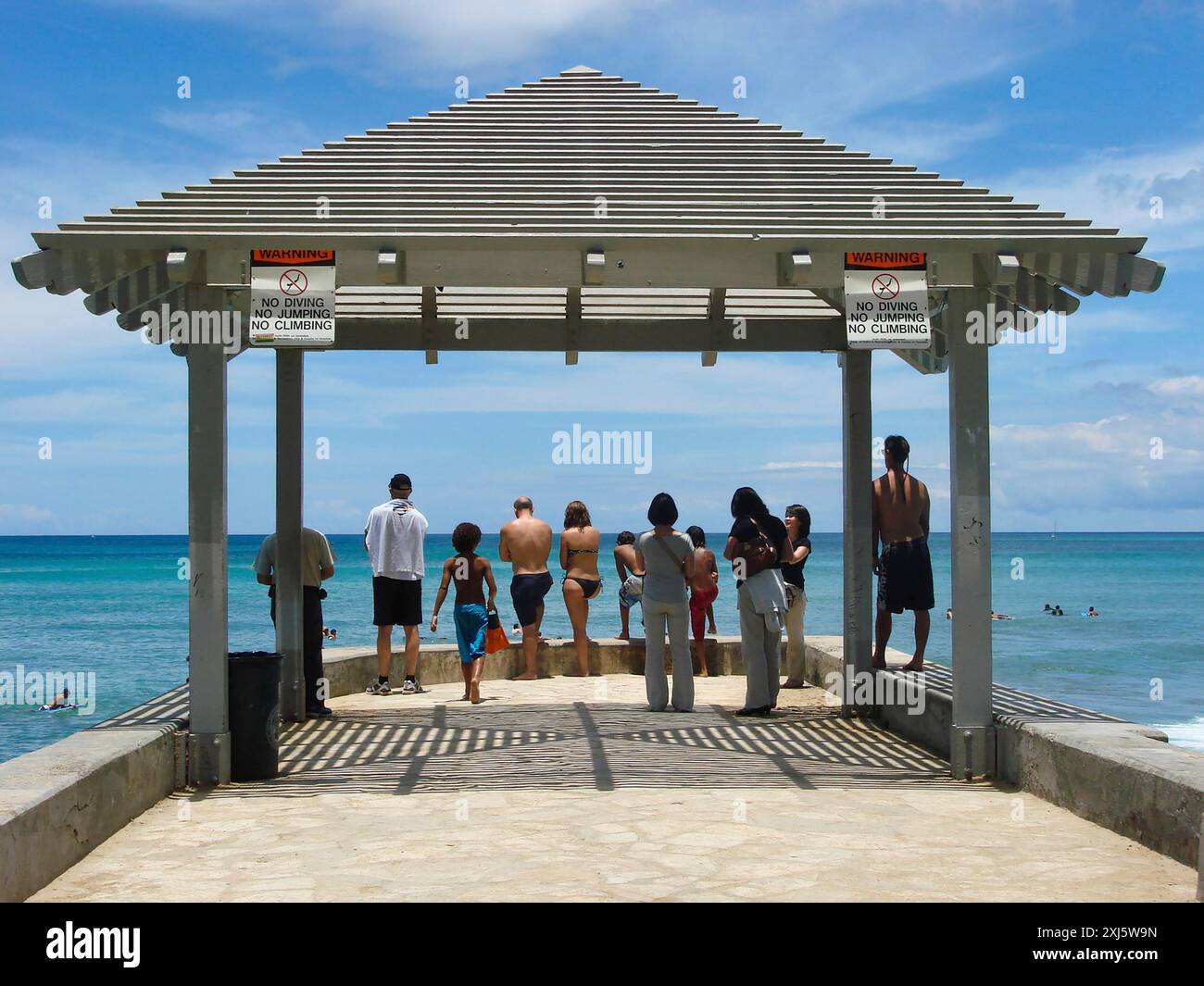 People at the end of Waikiki beach cement pier at Oahu, Hawaii, USA ...