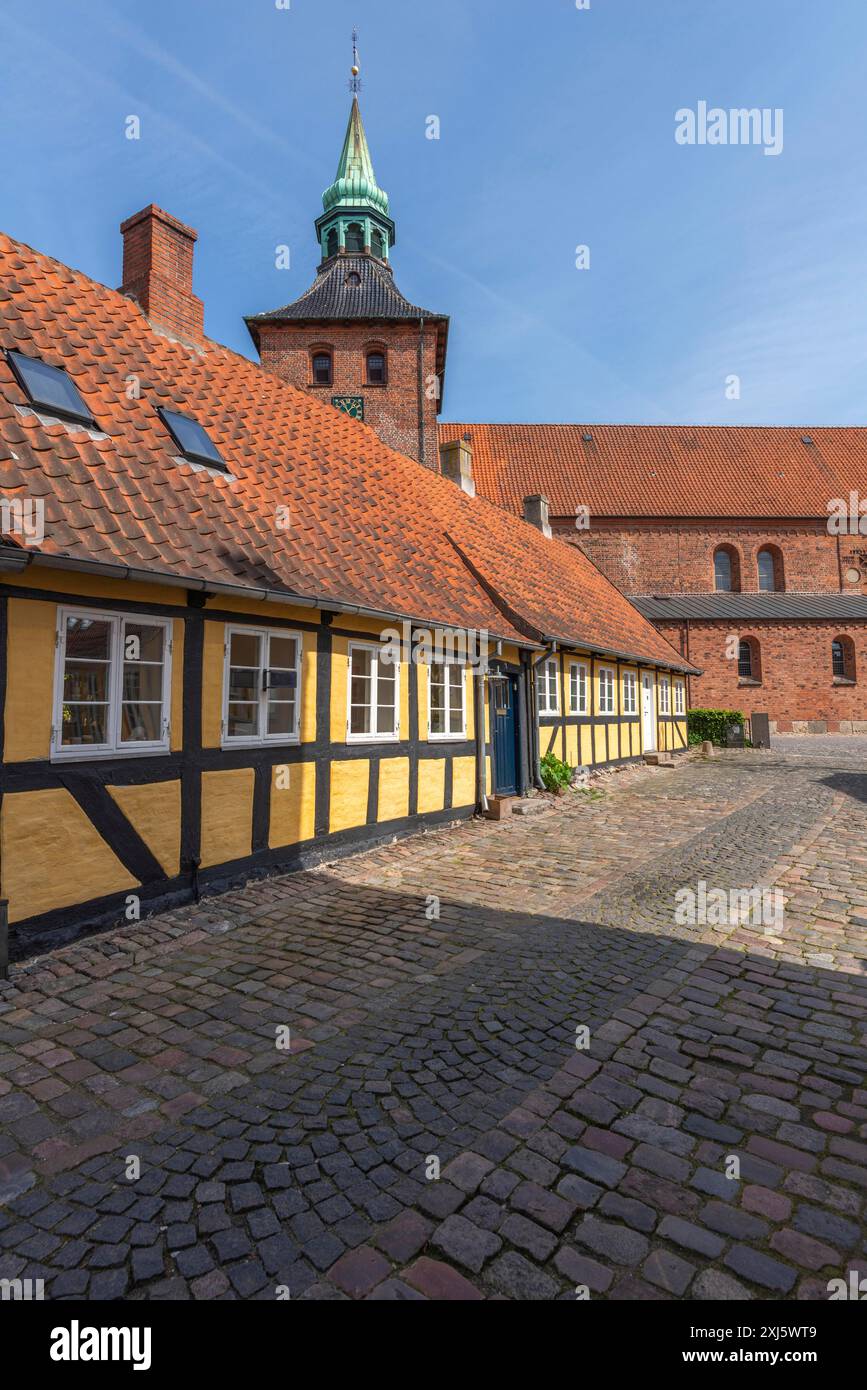 Svendborg Old Town, yellow, half-timbered house with St. Nicolai Church ...