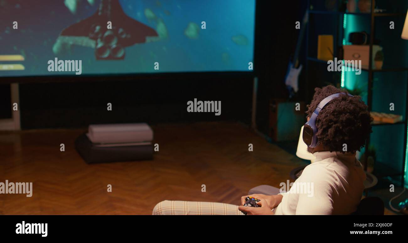 African american gamer plays game with spaceship shooting laser streams ...