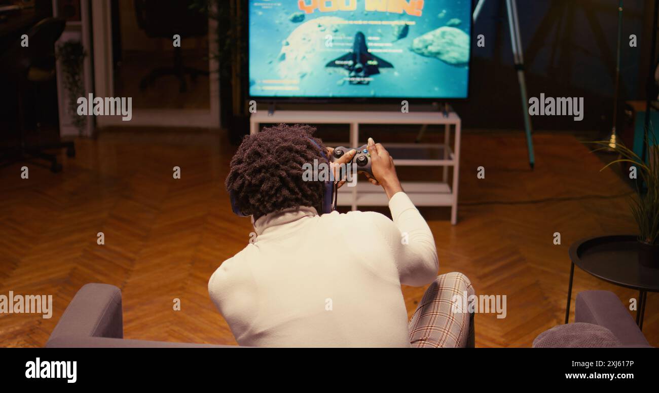BIPOC gamer receiving winner screen on smart TV after killing all foes ...