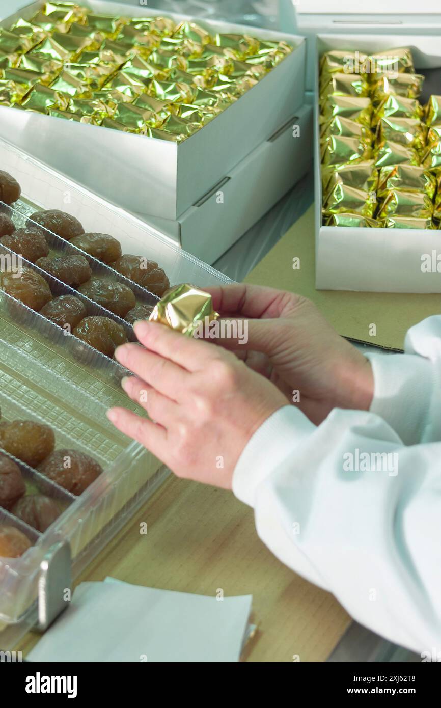 Making candied chestnuts :wrapping the candied chestnut Stock Photo - Alamy