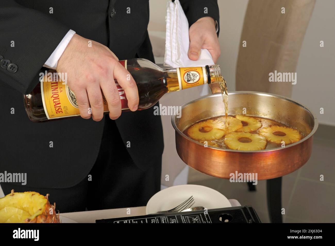 Preparing a pineapple flambé Stock Photo - Alamy