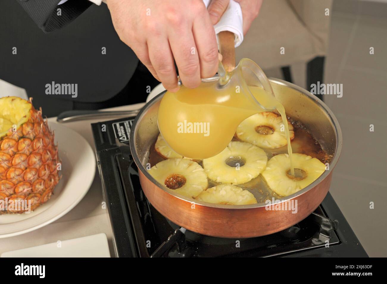 Preparing a pineapple flambé Stock Photo - Alamy