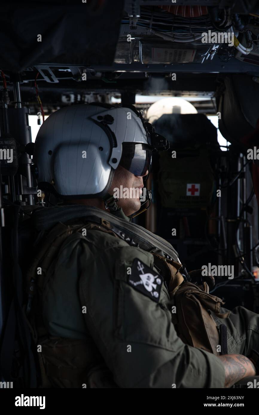 U.S. Naval Aircrewman (Helicopter) 1st Class Fabian Yuque, observes the ...