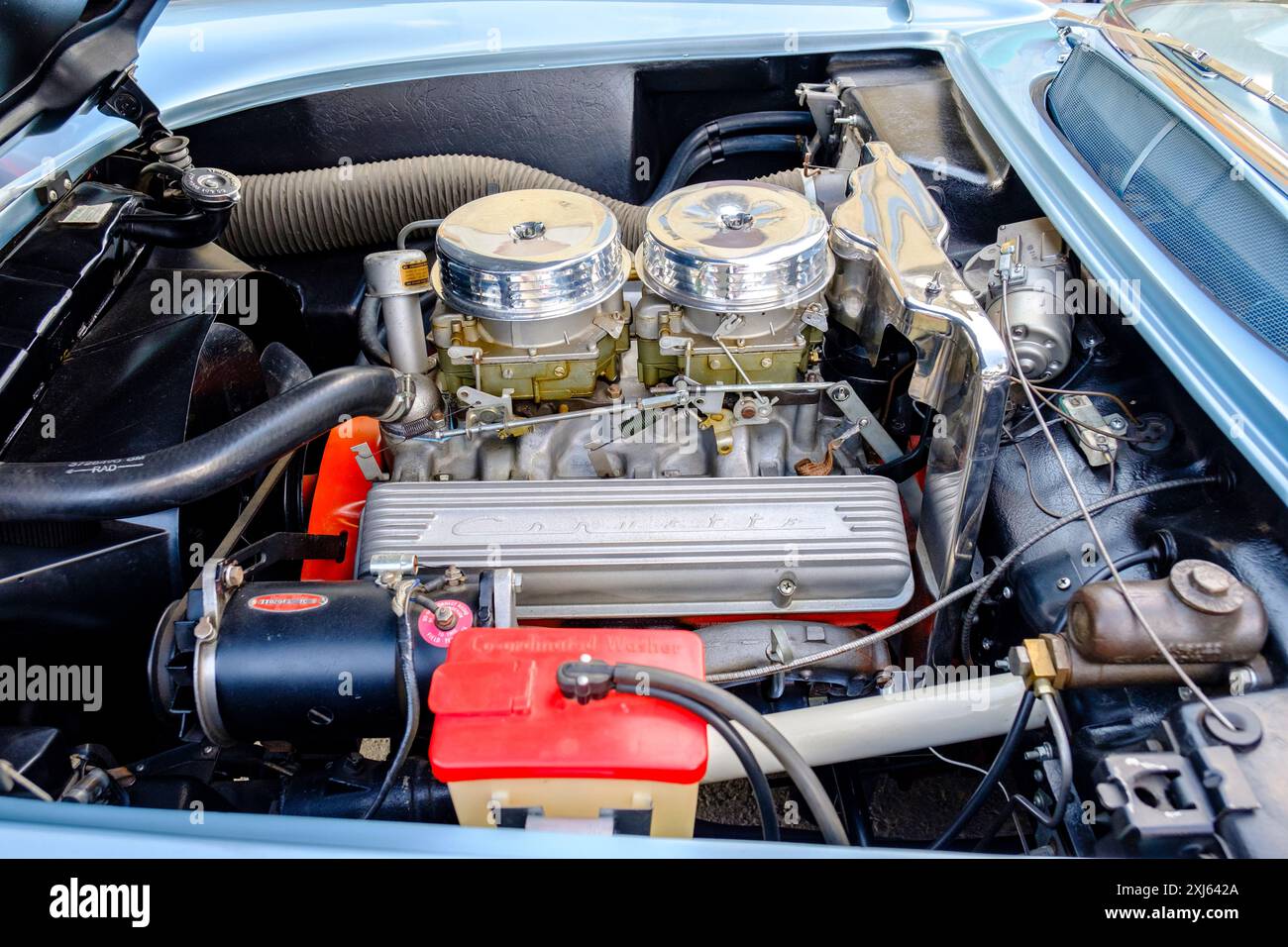 Open hood of blue 1957 Chevrolet Corvette convertible sports car showing engine bay motor and ...