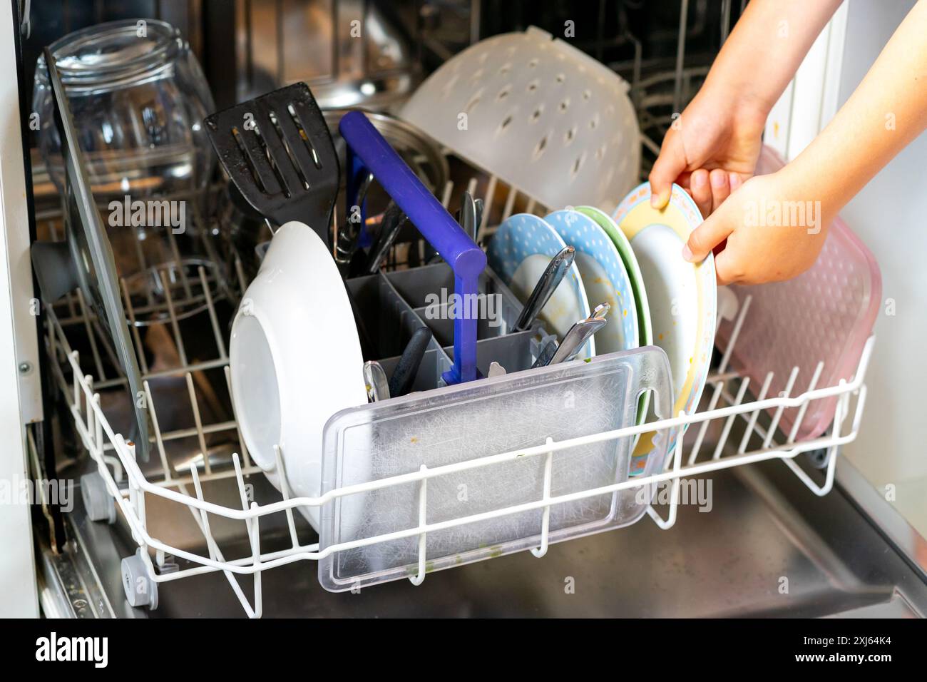 Children's hands load dirty dishes into the dishwasher Stock Photo - Alamy