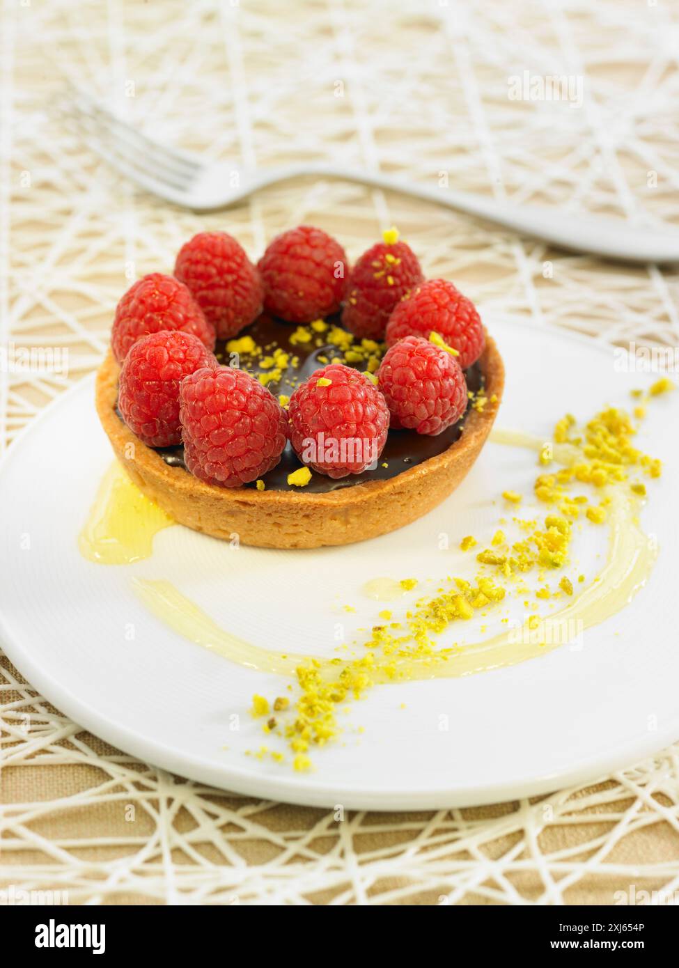 Chocolate-raspberry tartlet with crushed pistachios Stock Photo - Alamy
