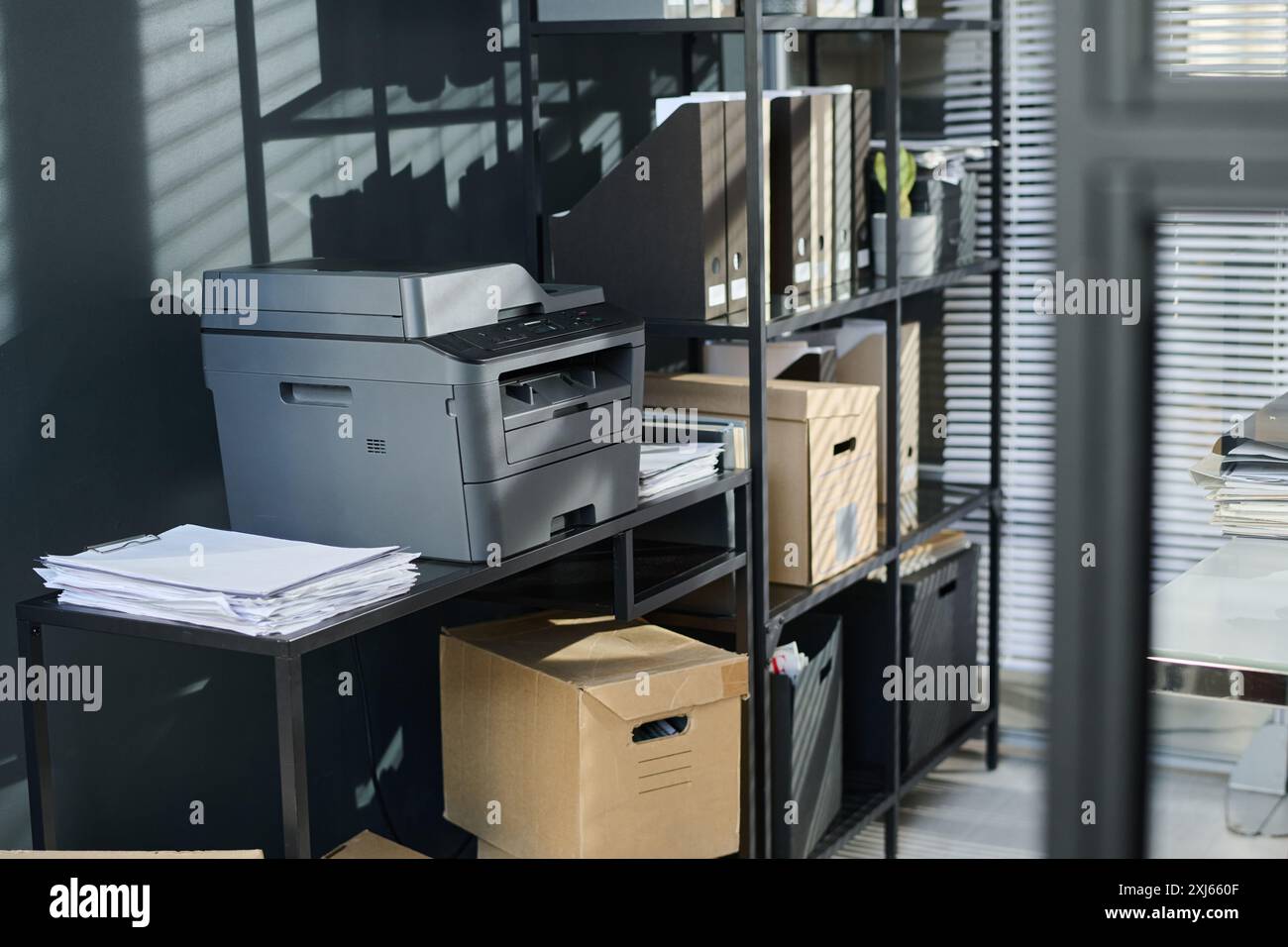 Plastic copier machine standing on desk with stack of paper documents ...