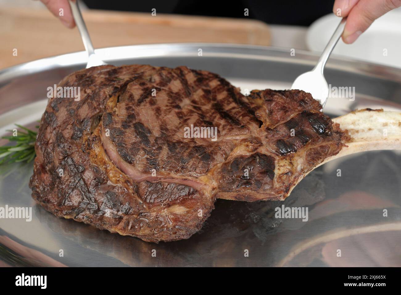 Carving a thick beef chop Stock Photo - Alamy