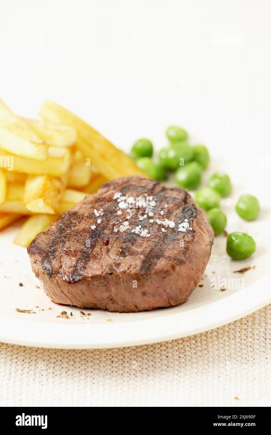 Grilled rump steak with peas and french fries Stock Photo - Alamy