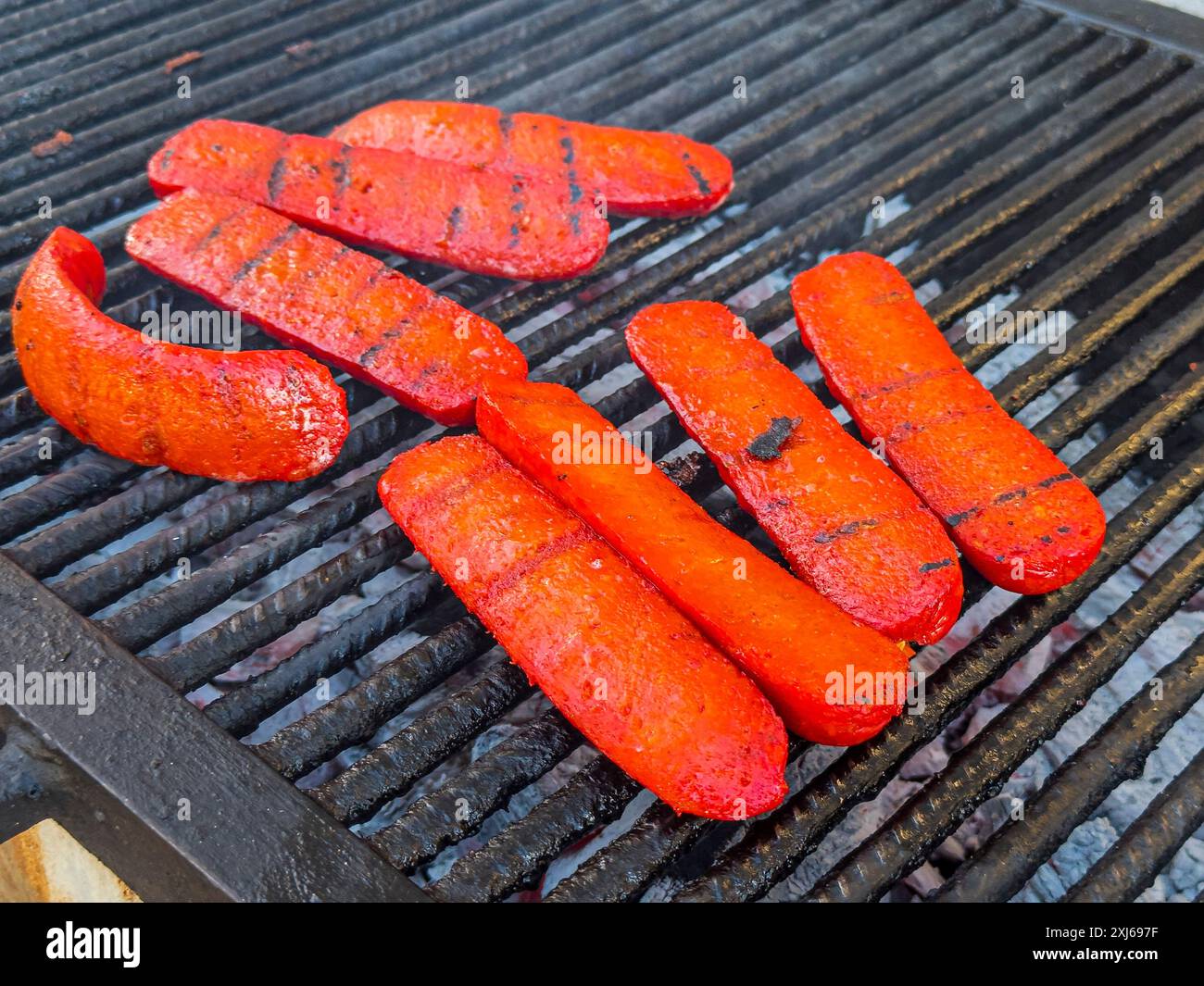 Sausages to grill on the spit or grill with charcoal embers in a ...