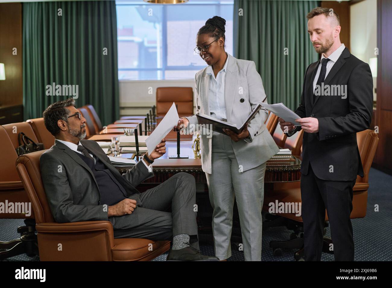 Young smiling female secretary passing paper document to mature male ...