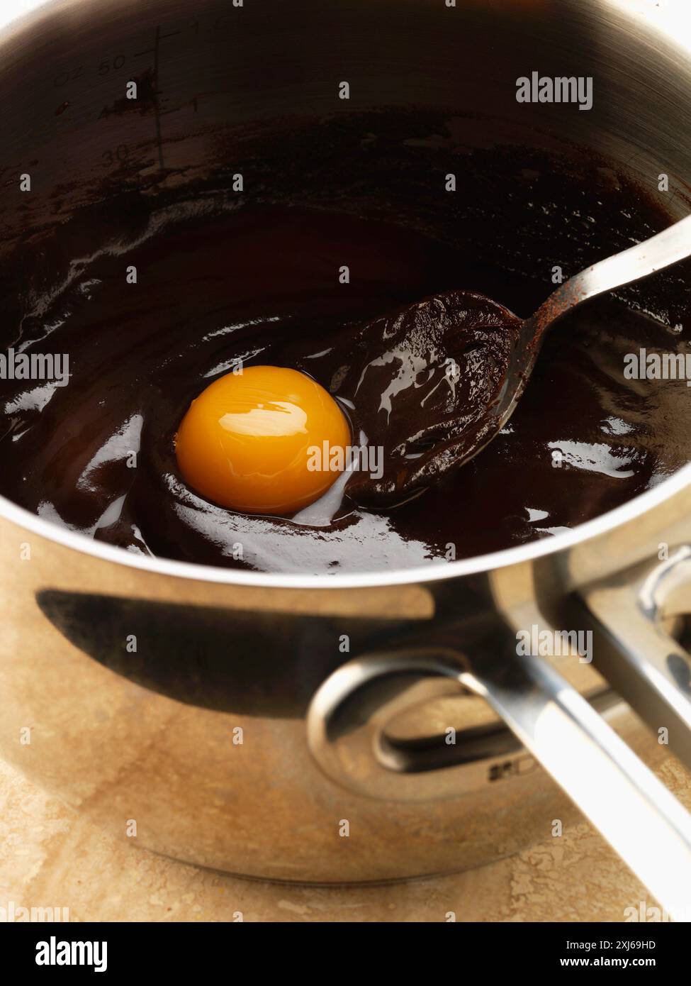 Mixing the egg yolk with the melted chocolate Stock Photo - Alamy
