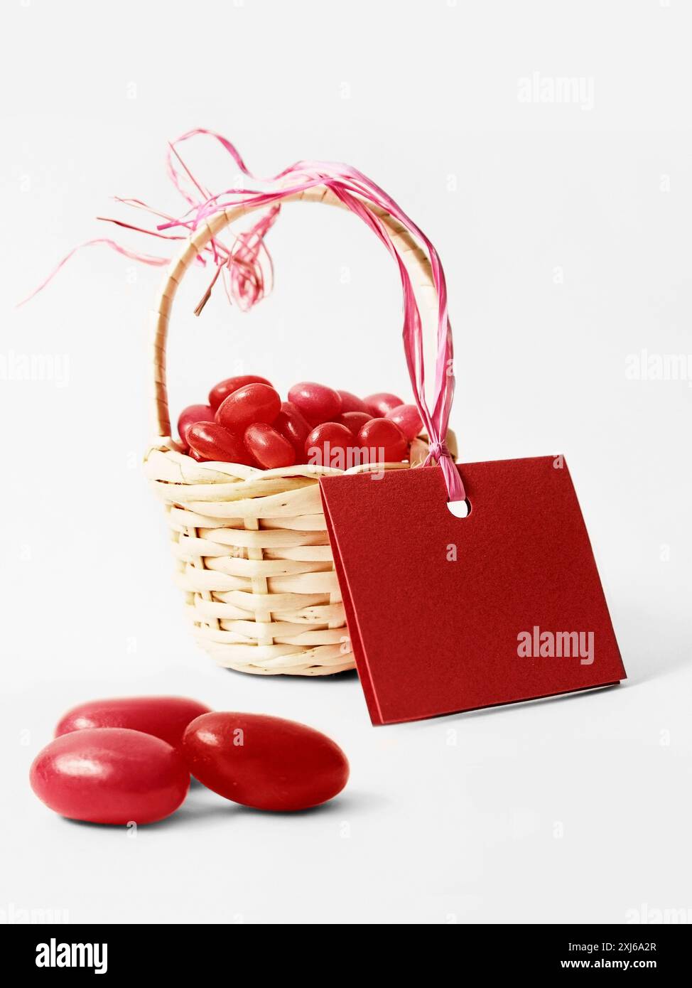 Small basket of red jelly beans and a label Stock Photo - Alamy
