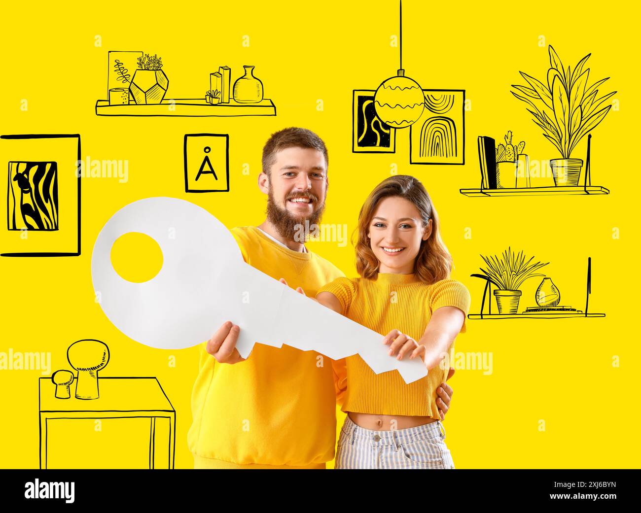 Happy young couple with big paper key in drawn interior of their new ...