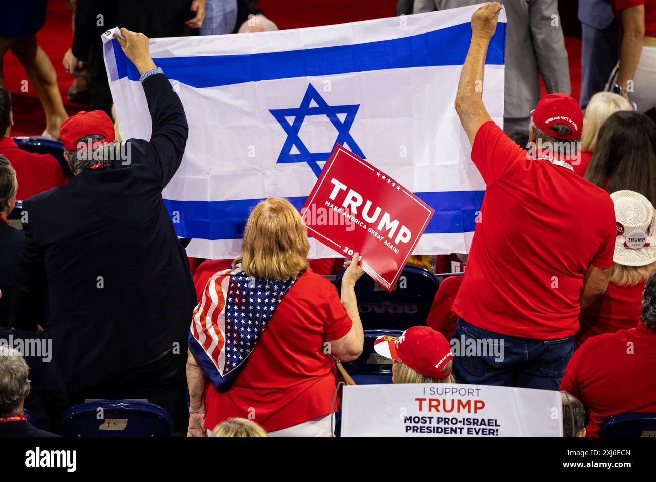 People hold an Israeli flag and signs supporting former President ...