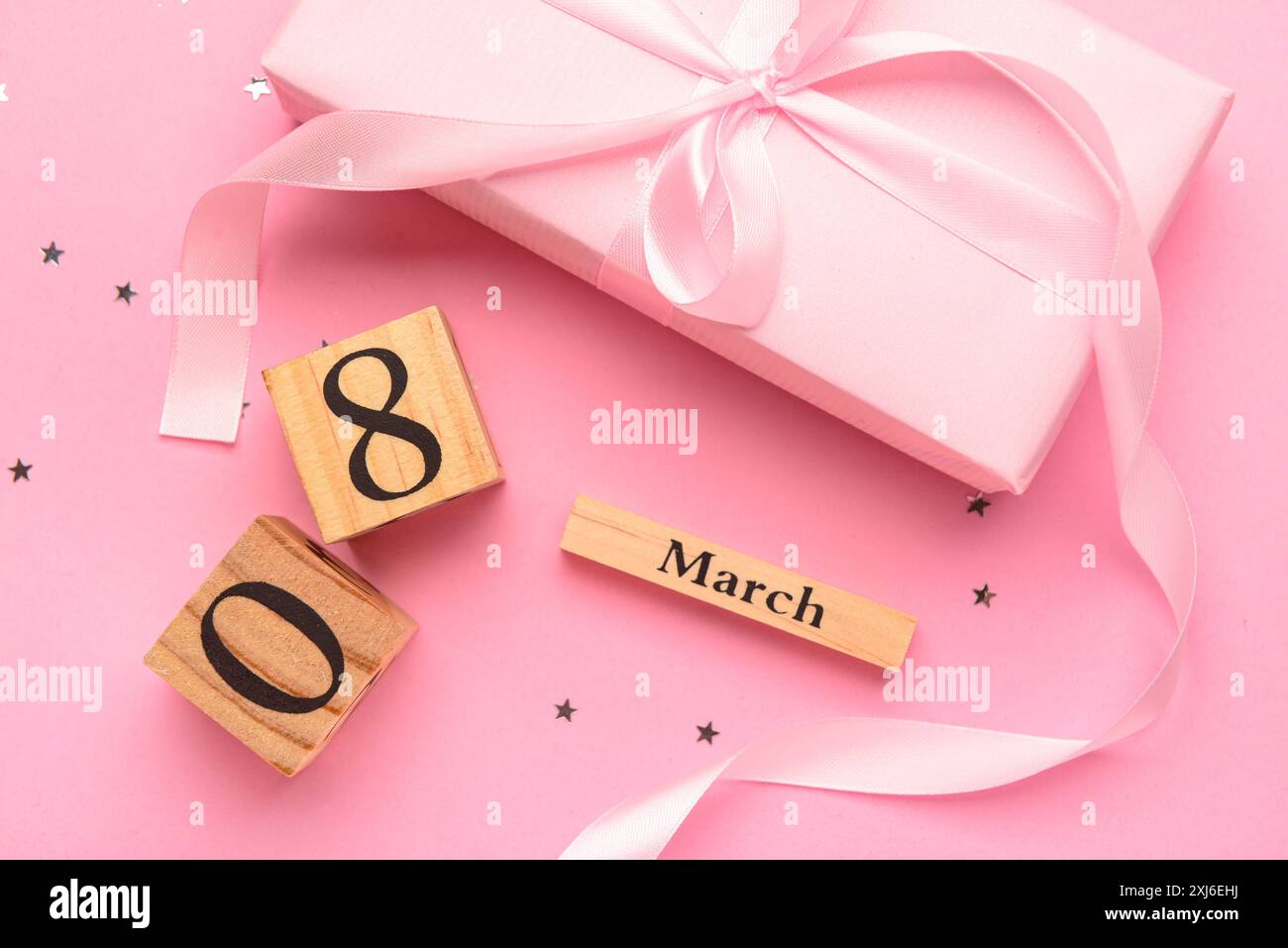 Cube calendar with date MARCH 8, gift box tied up with pink ribbon and ...