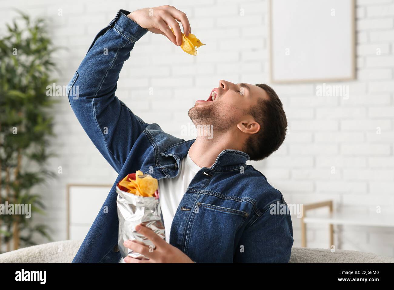 Man eating golden potato chip hi-res stock photography and images - Alamy