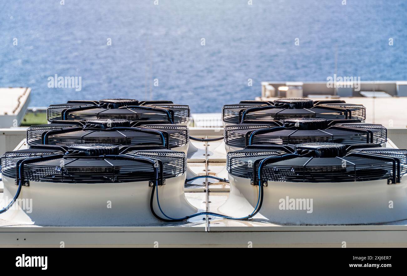 Six large black HVAC air conditioning units installed on a rooftop with ...