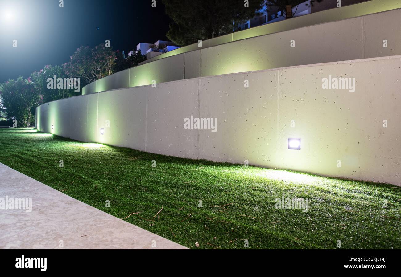 Modern LED lighting fixtures embedded in a curved white wall, casting ...