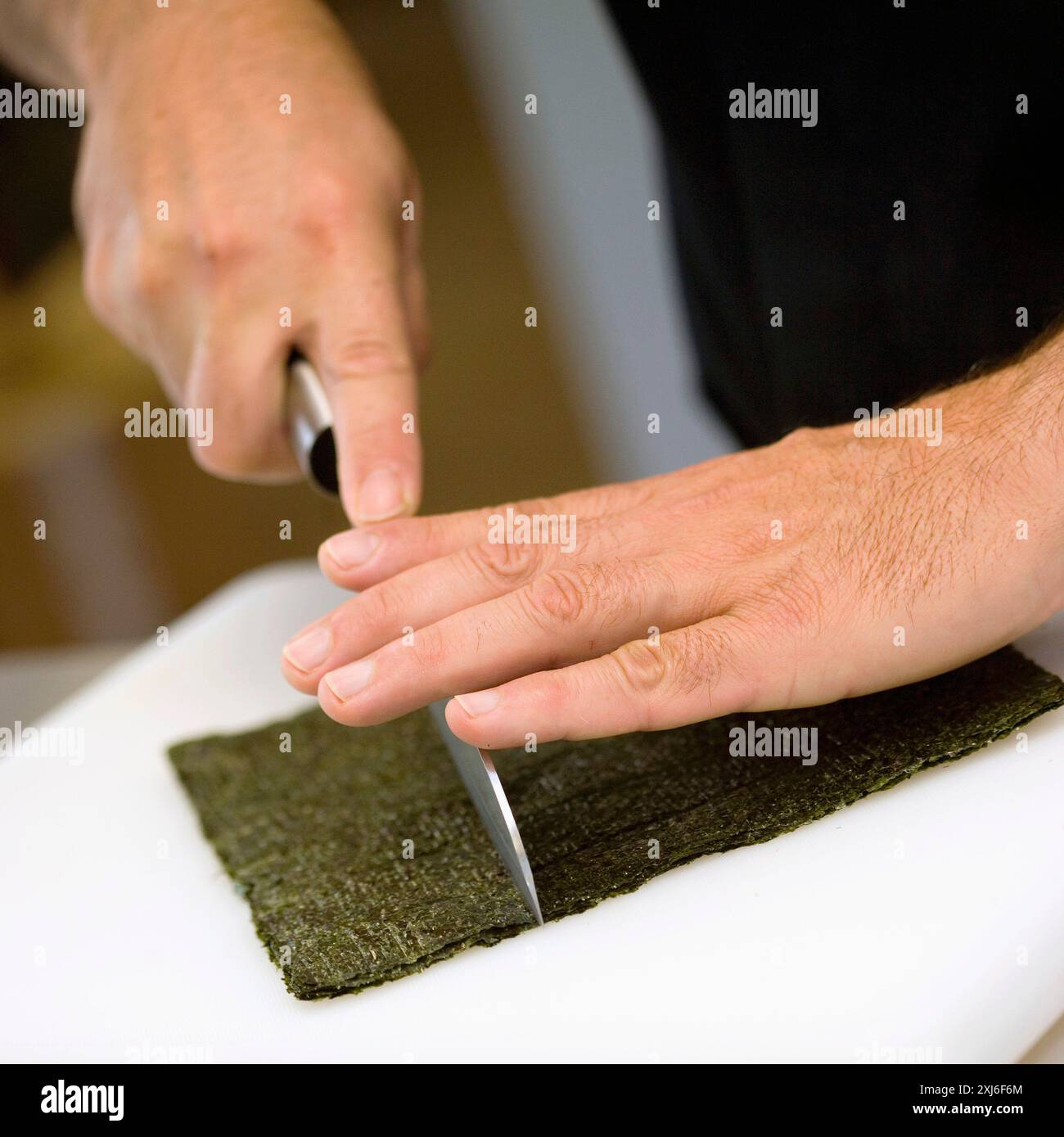 Cutting seaweed sheets for makis Stock Photo - Alamy