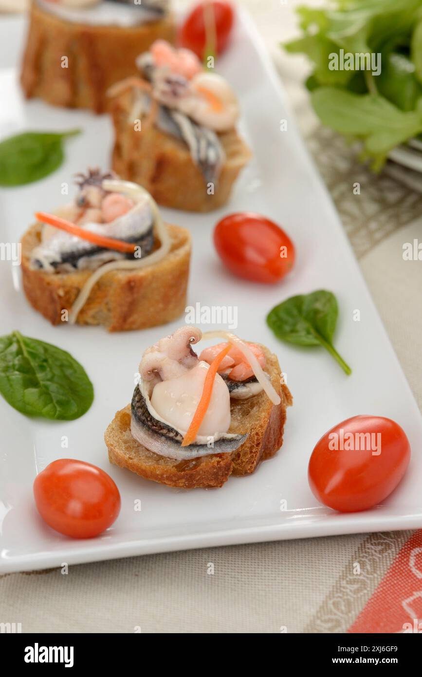 Squid,shrimp and anchovy canapés Stock Photo - Alamy