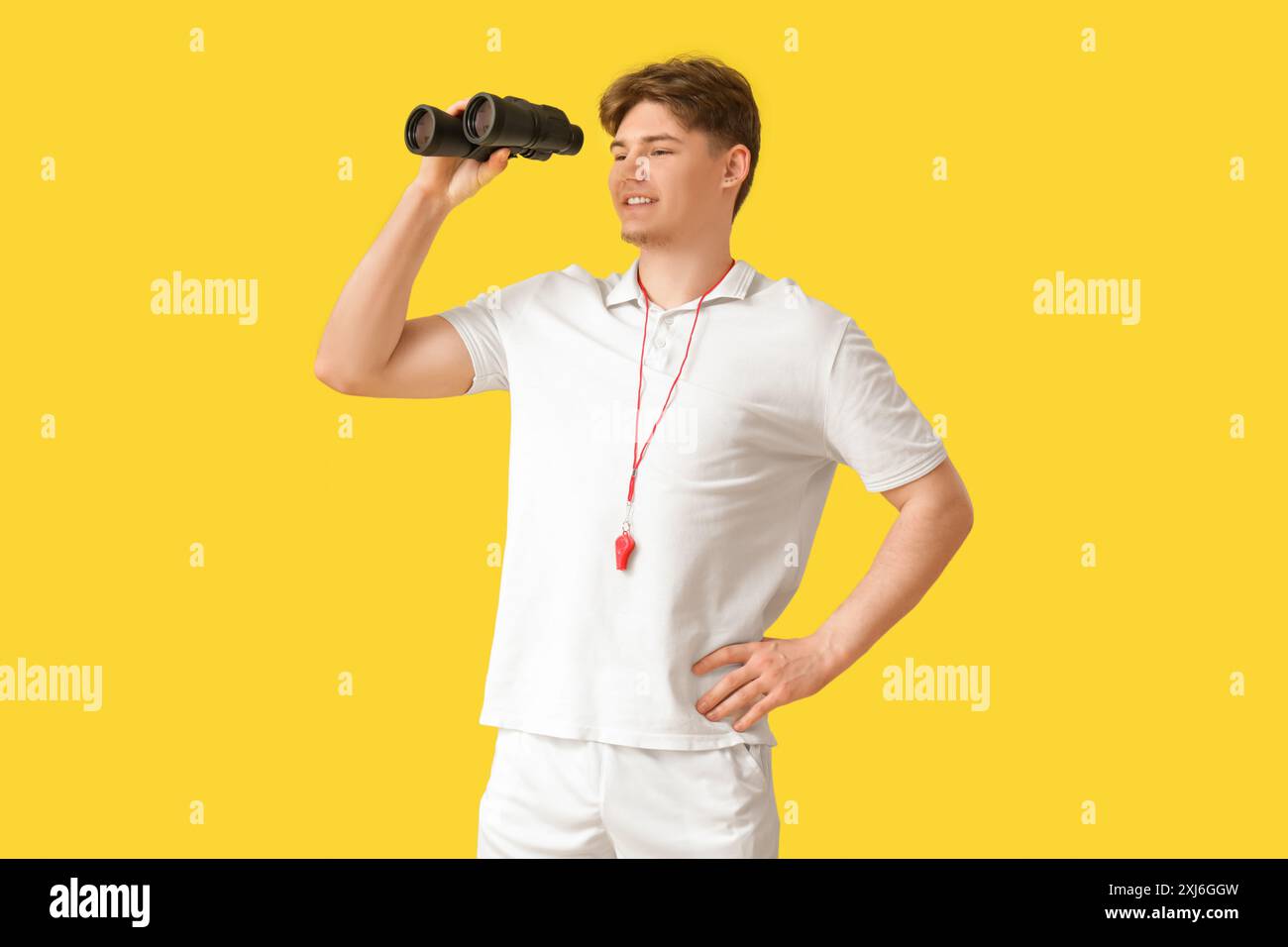 Male lifeguard with binoculars on yellow background Stock Photo - Alamy