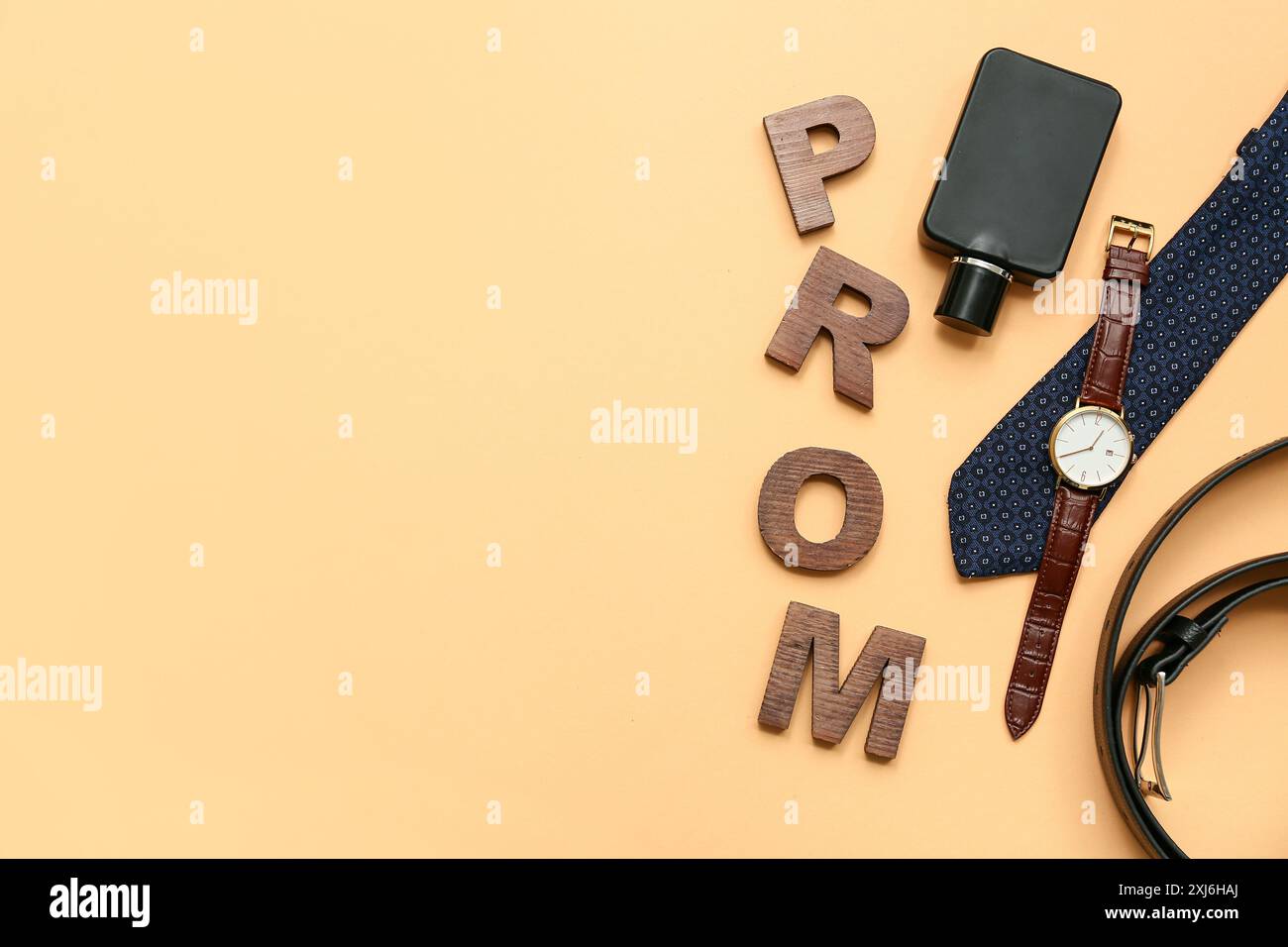 Word PROM with wristwatch, belt and perfume bottle on beige background ...