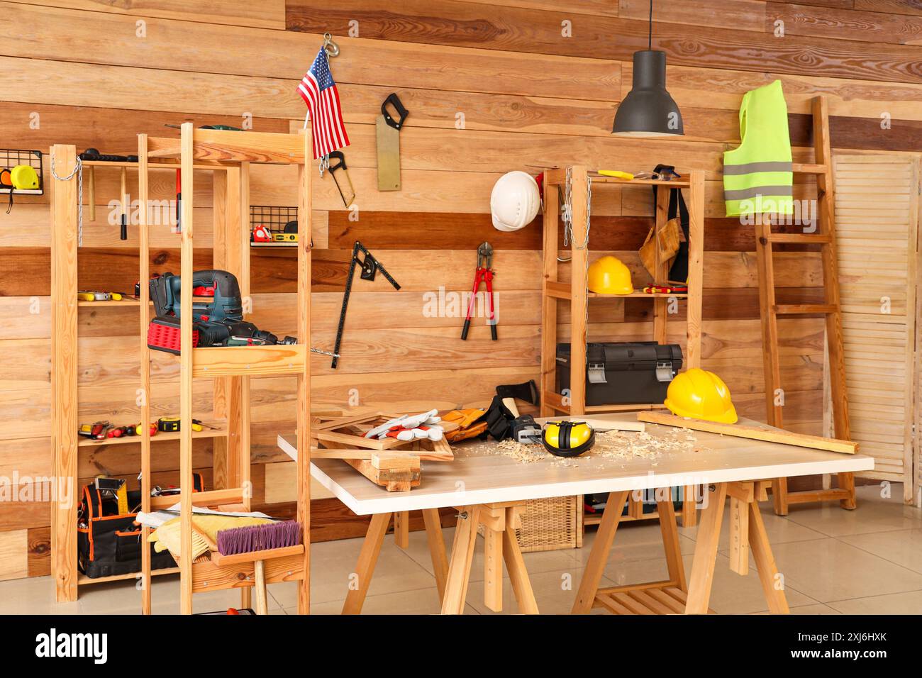 Interior of carpenter's workshop with tools on shelves and USA flag ...