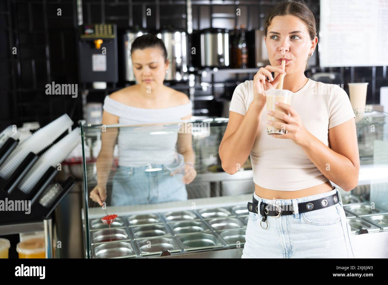 Happy girl drinking bubble tea also known as tapioca tea, pearl milk ...