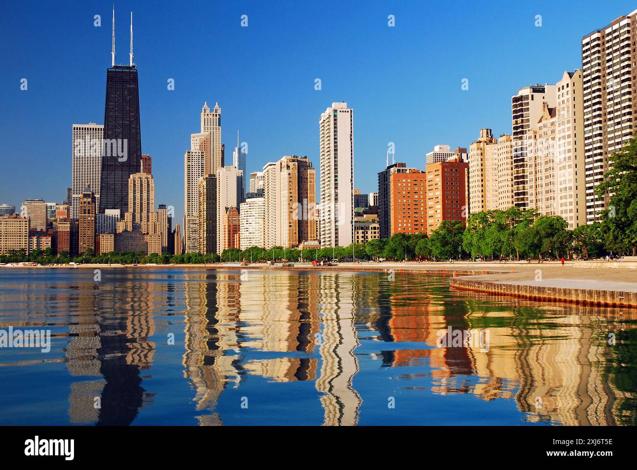 The skyline of Chicago is reflected in the calm waters of Lake Michigan ...