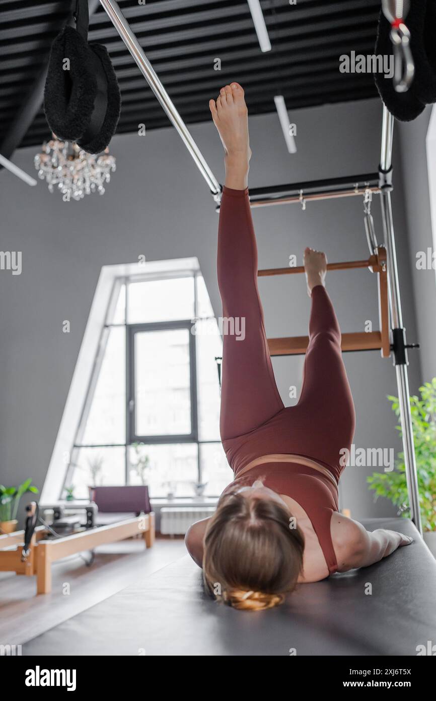 Woman doing pilates exercises on Balanced Body Cadillac machine at ...