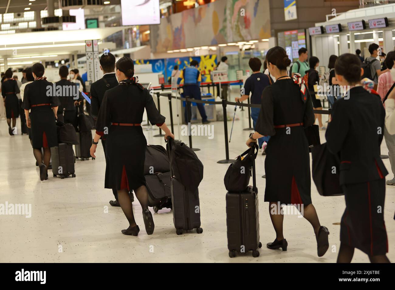 JAL flight attendants walk through the terminal of Haneda Airport after ...