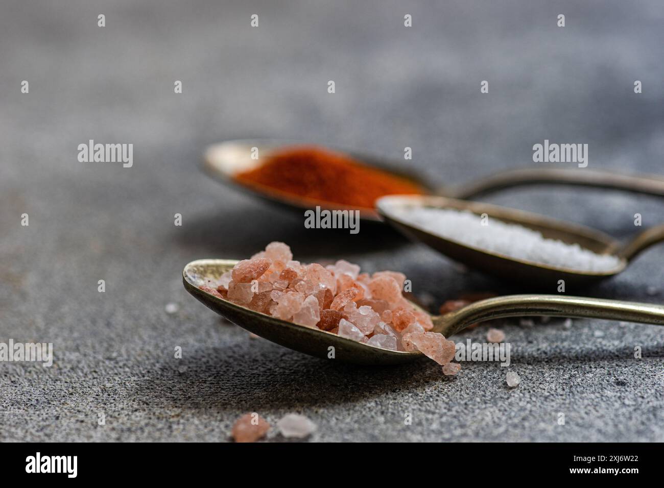 Close-up of three vintage teaspoons with himalayan pink salt, spicy ...