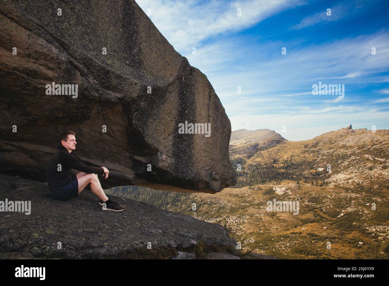 A traveller contemplates nature beneath a hanging stone Stock Photo - Alamy