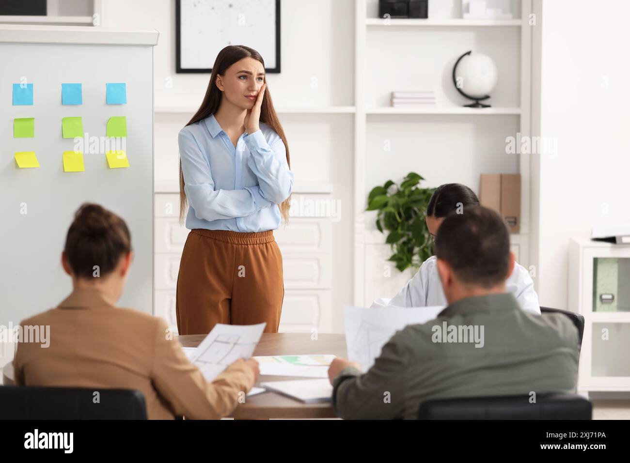 Woman feeling embarrassed during business meeting in office Stock Photo ...