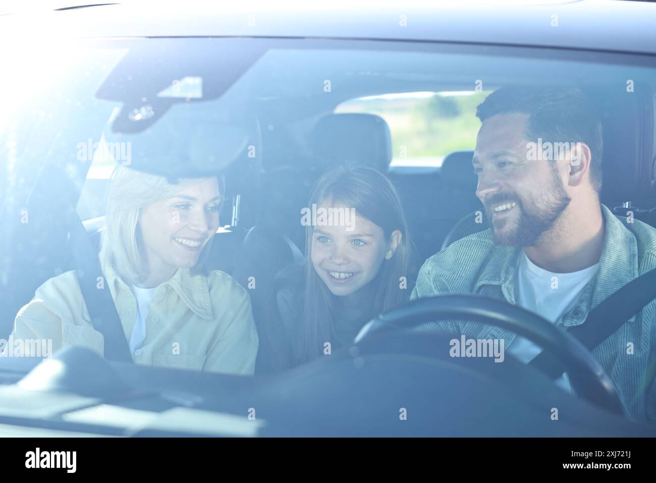 Happy family with cute daughter inside car together, view through ...