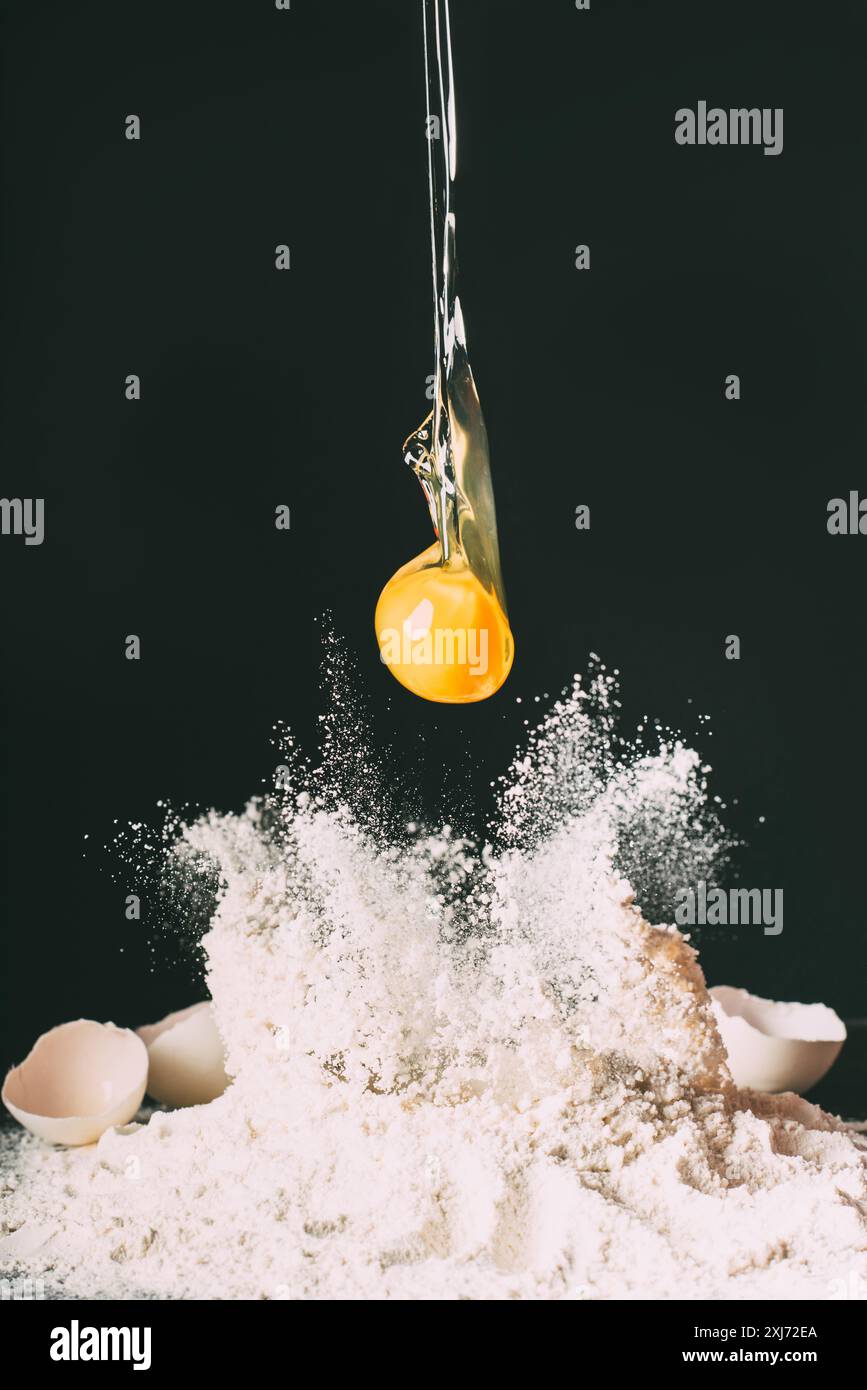 close up view of yolk falling on flour on black background Stock Photo - Alamy