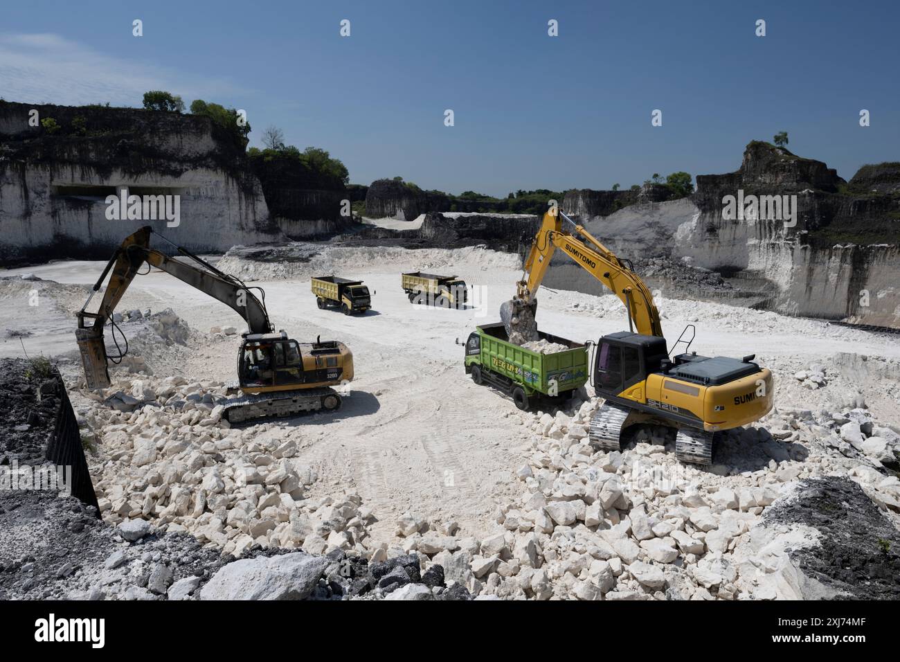Heavy duty hydraulic excavator and a hydraulic jackhammer used to extract calcium carbonate from ...