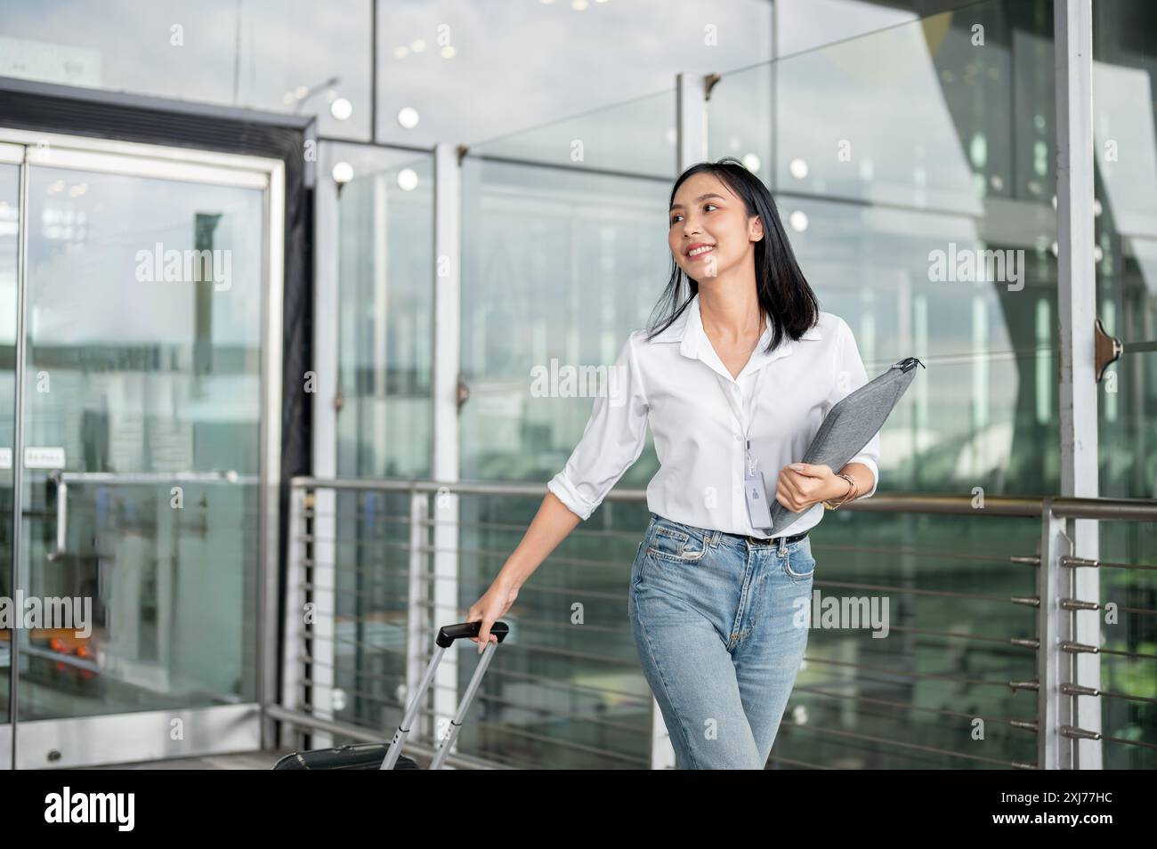 A confident, beautiful Asian female passenger is walking out of the ...