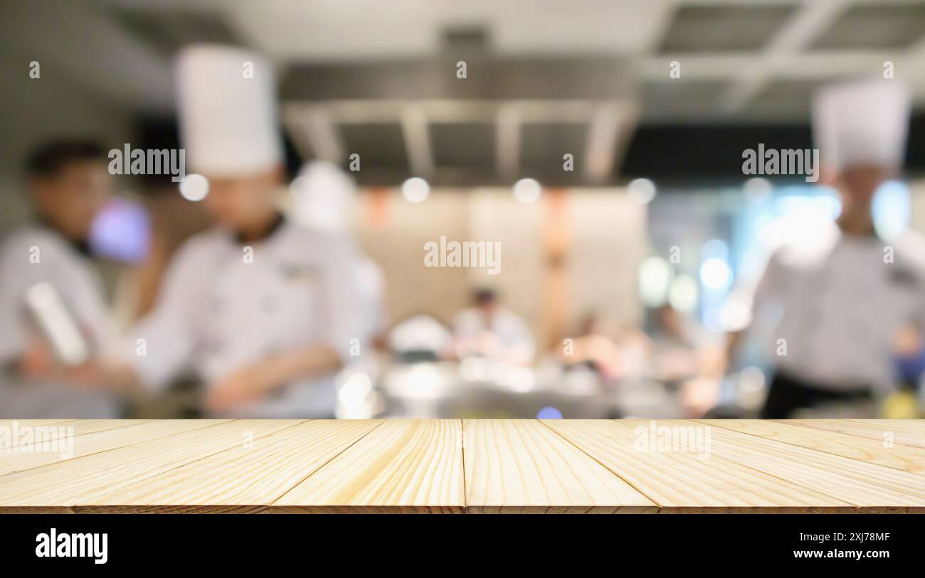 Empty Wood table top with Chef cooking in restaurant kitchen blurred ...